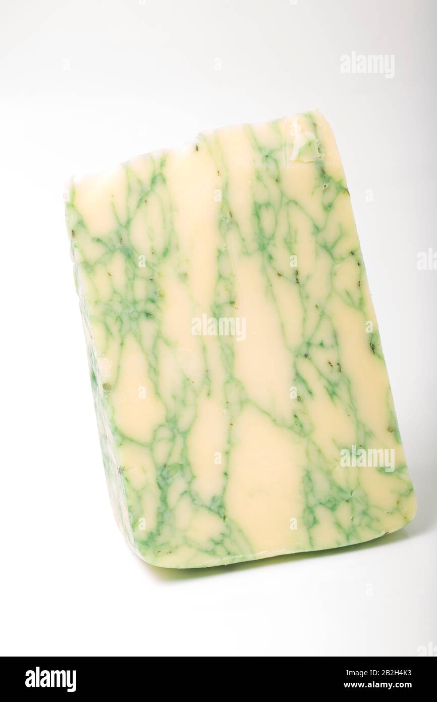 A wedge of Sage Derby cheese made with cow’s milk that has been ...