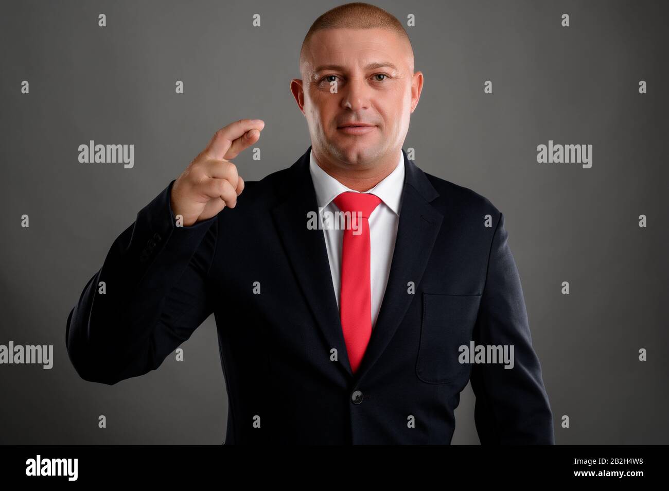 Businessman dressed in suit showing good luck Stock Photo - Alamy