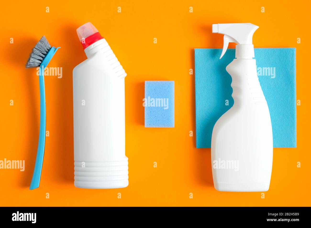 Set of cleaning supplies on orange background. Flat lay blue rag ...