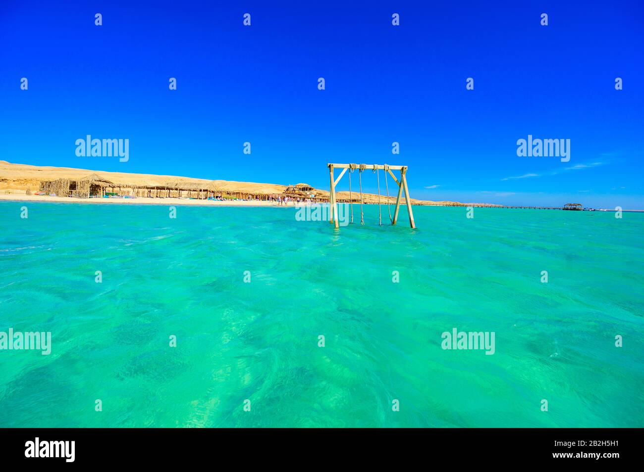 Swing in crystal clear azure water - Orange Bay Beach with white beach ...
