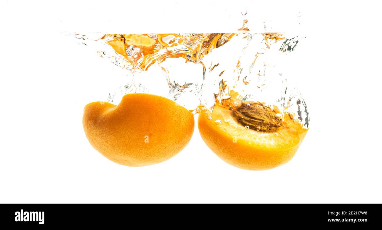 Fresh ripe peach split in half falling in the clear water Stock Photo ...