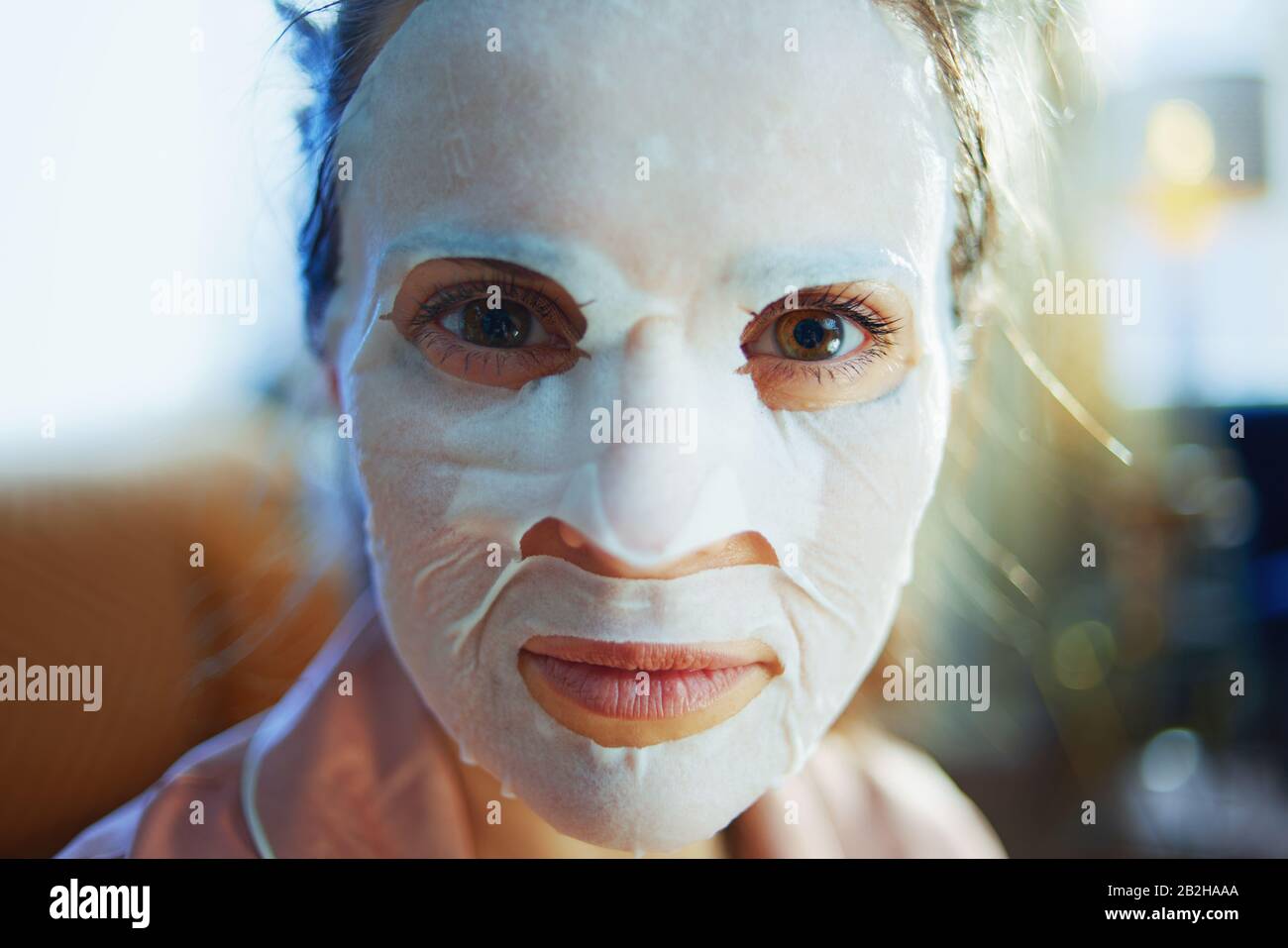 Portrait of elegant 40 years old woman in pajamas with white sheet ...