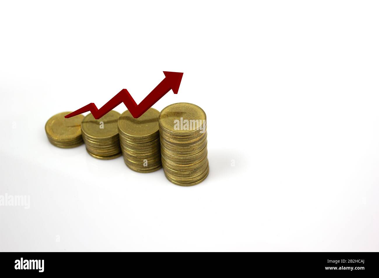 Growing stack of coins with rising red arrow on white background with ...