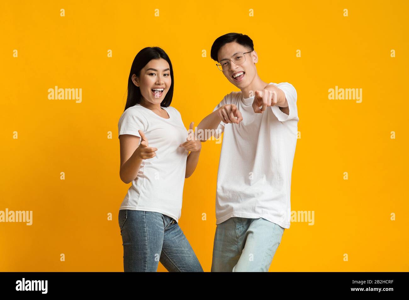 Happy asian couple having fun over yellow background Stock Photo - Alamy