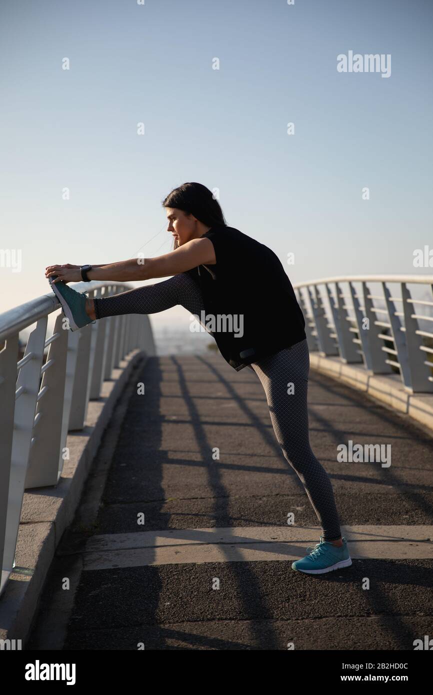 Side view woman stretching before running Stock Photo - Alamy