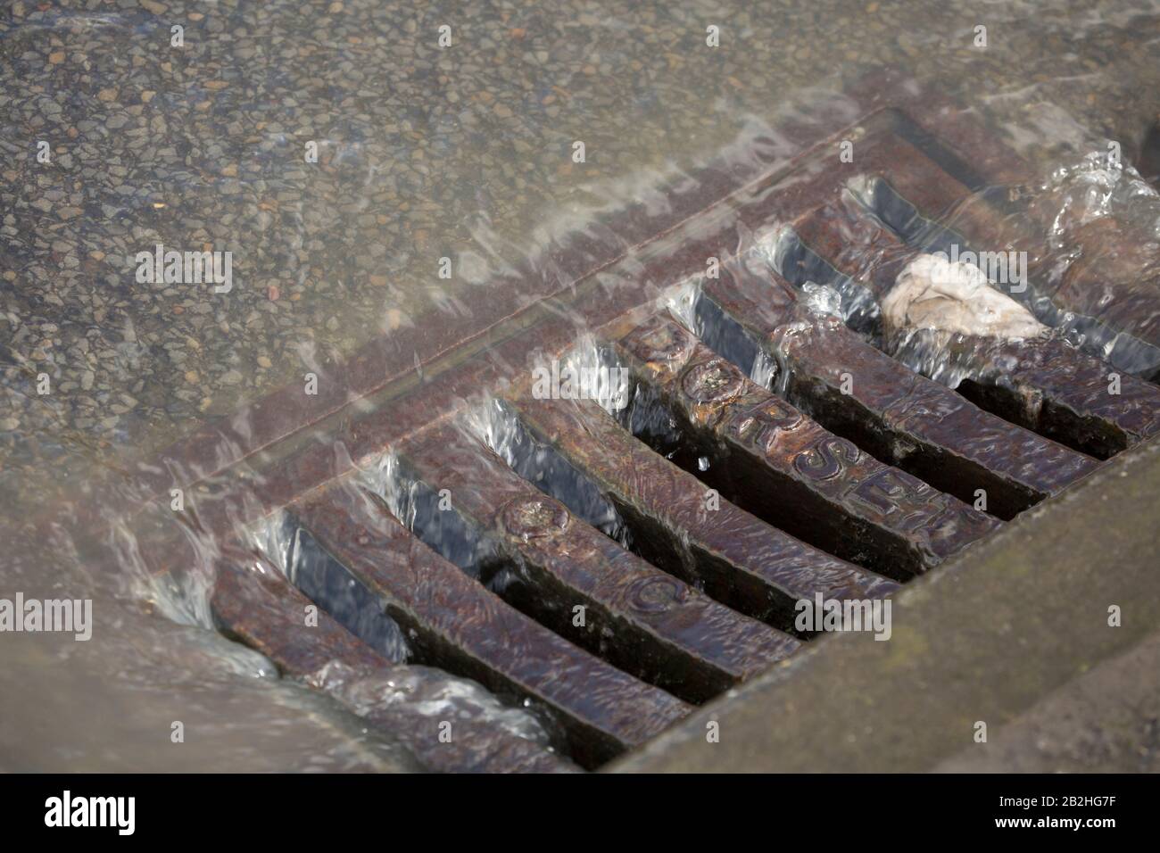 Water pouring down a drain in a road near Gillingham in Dorset ...