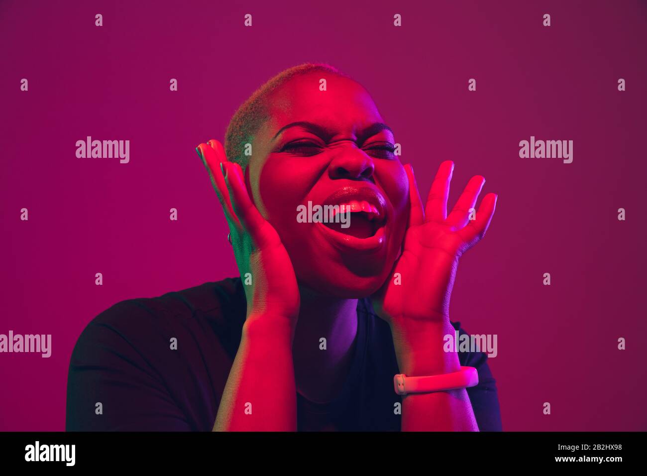 Shouting, calling. African-american young woman's portrait on purple ...