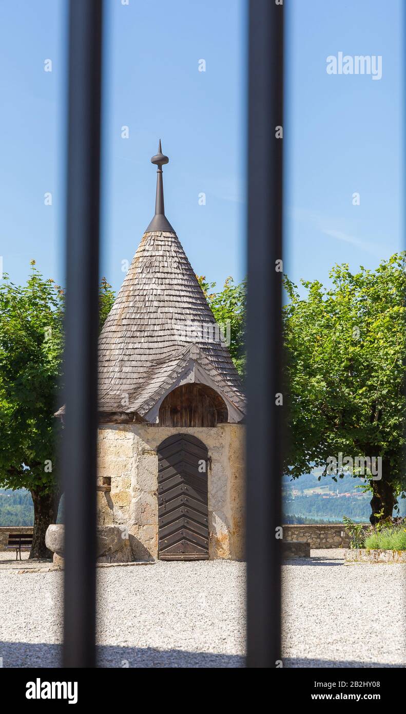 View through the iron fence on the small rusty house with the straw ...