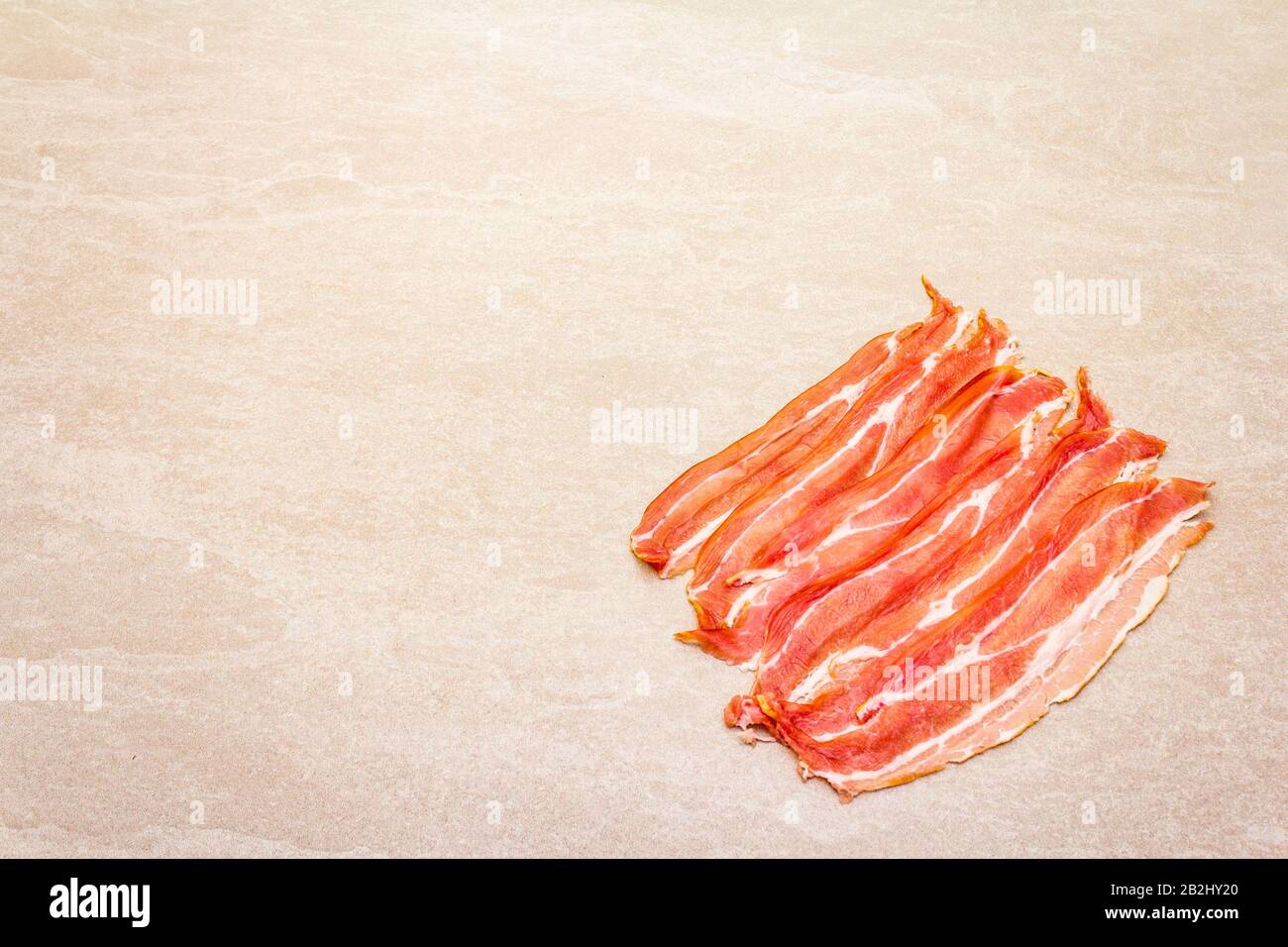 Smoked bacon slices. Raw stripes on stone background Stock Photo - Alamy