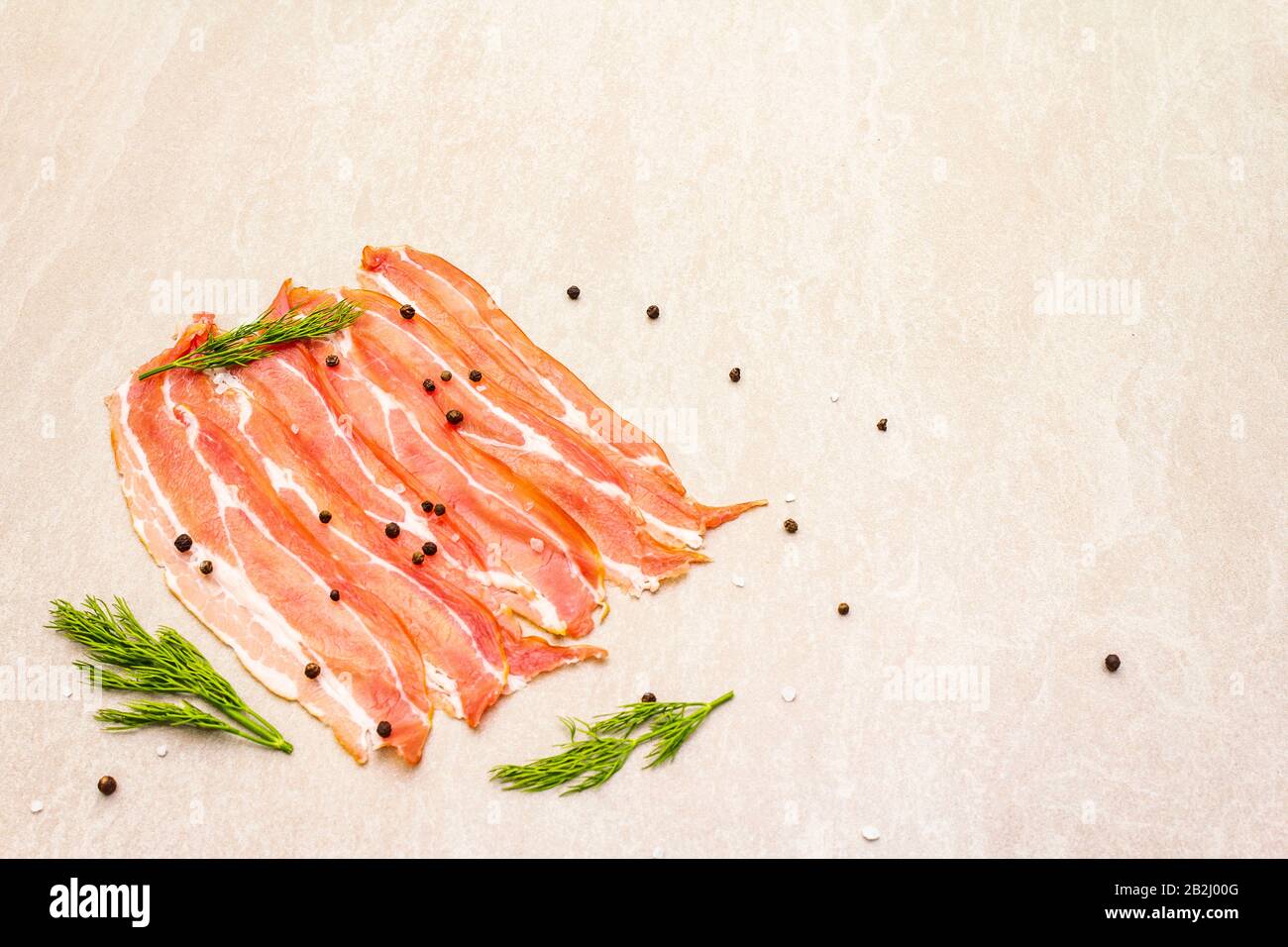 Smoked bacon slices. Raw stripes with black pepper and fresh dill on ...