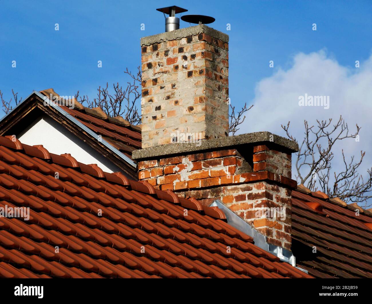 old, cracked brick chimney. concrete cap stones. red brown clay roof ...