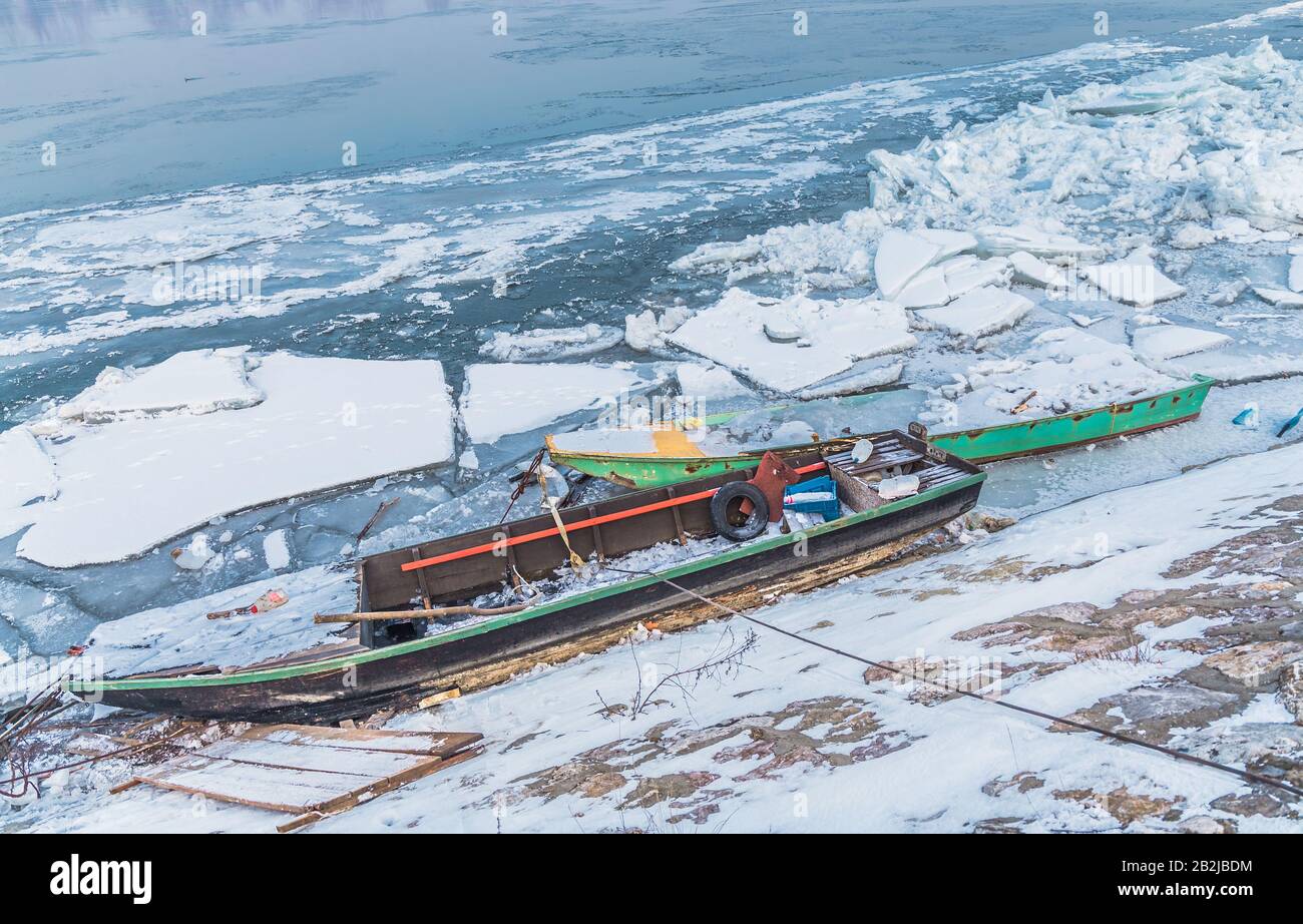 Two multicolor fishing boats trapped on frozen river Danube and many ...