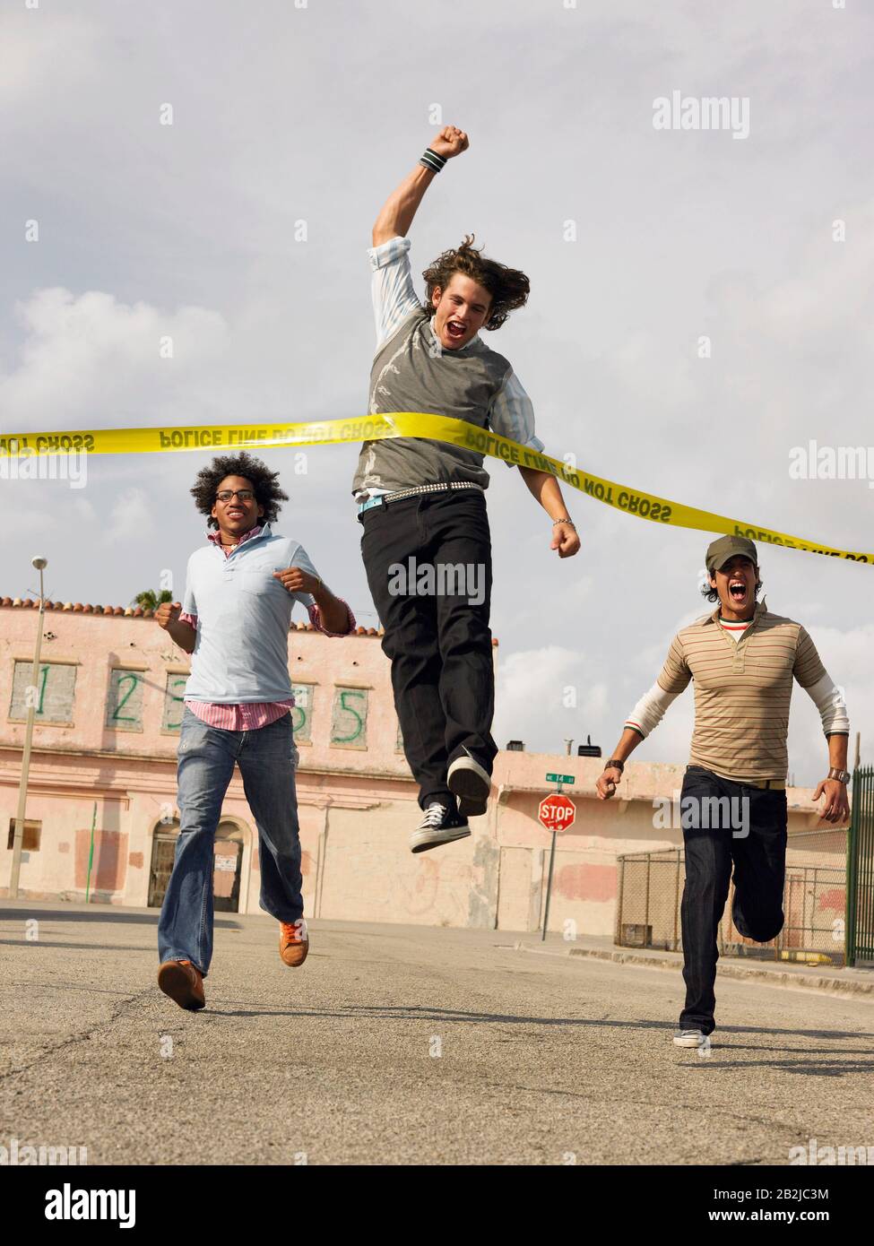 Friends racing to police tape in street Stock Photo - Alamy