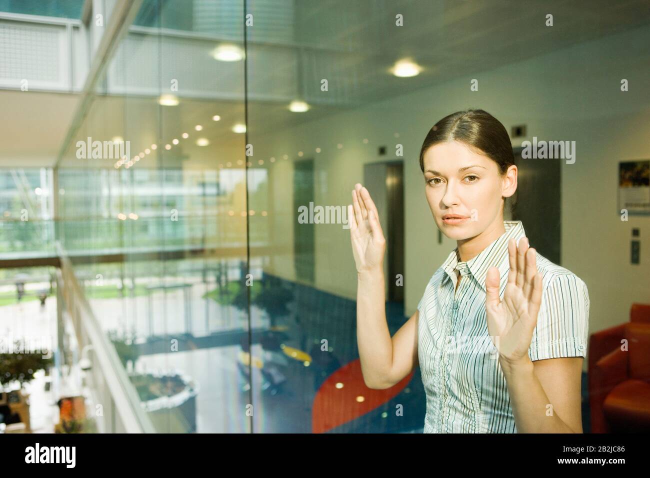 Woman Behind Glass Wall in office portrait Stock Photo - Alamy