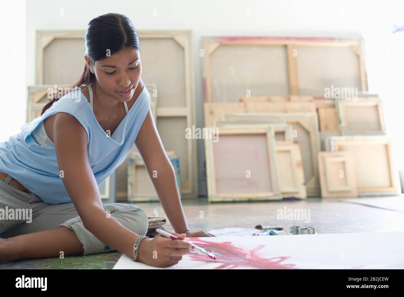 Artist Working on Canvas on Floor of Studio Stock Photo - Alamy