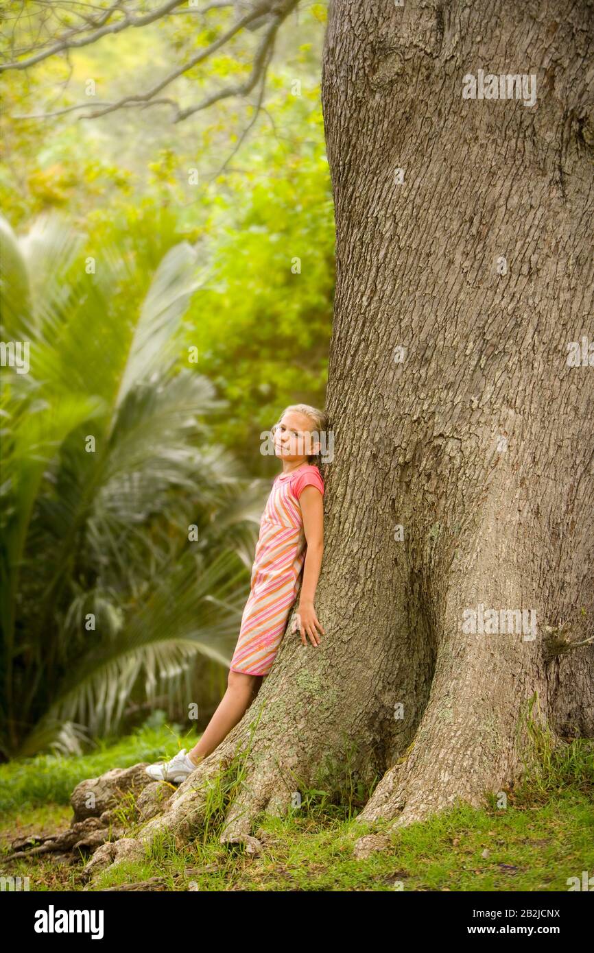 Girl Standing by Large Tree Stock Photo - Alamy
