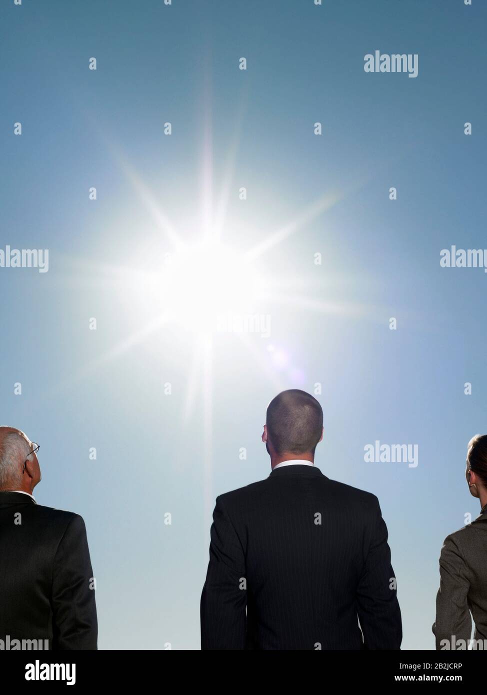 Three business people looking at the sun half length back view cropped ...