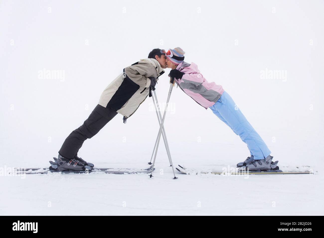 Couple leaning towards each other standing on skis side view Stock ...