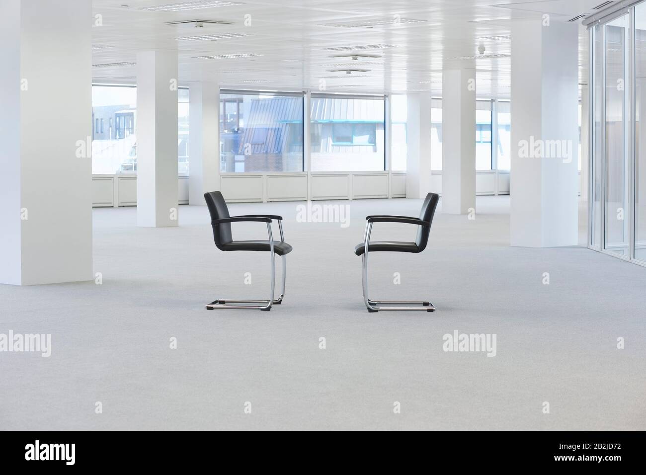 Two facing chairs in empty office space Stock Photo - Alamy