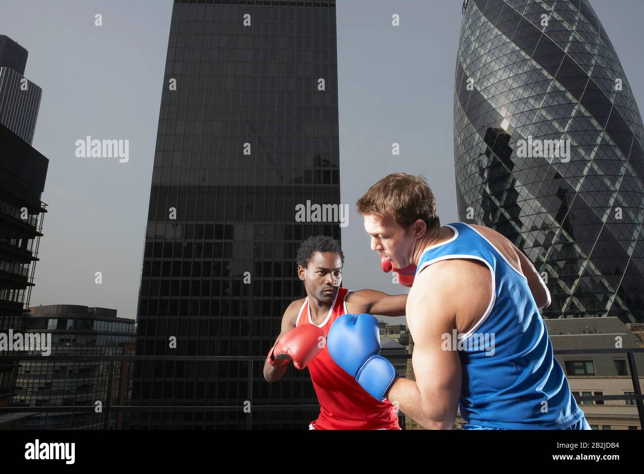 Two boxers fighting amongst downtown buildings low angle view London ...