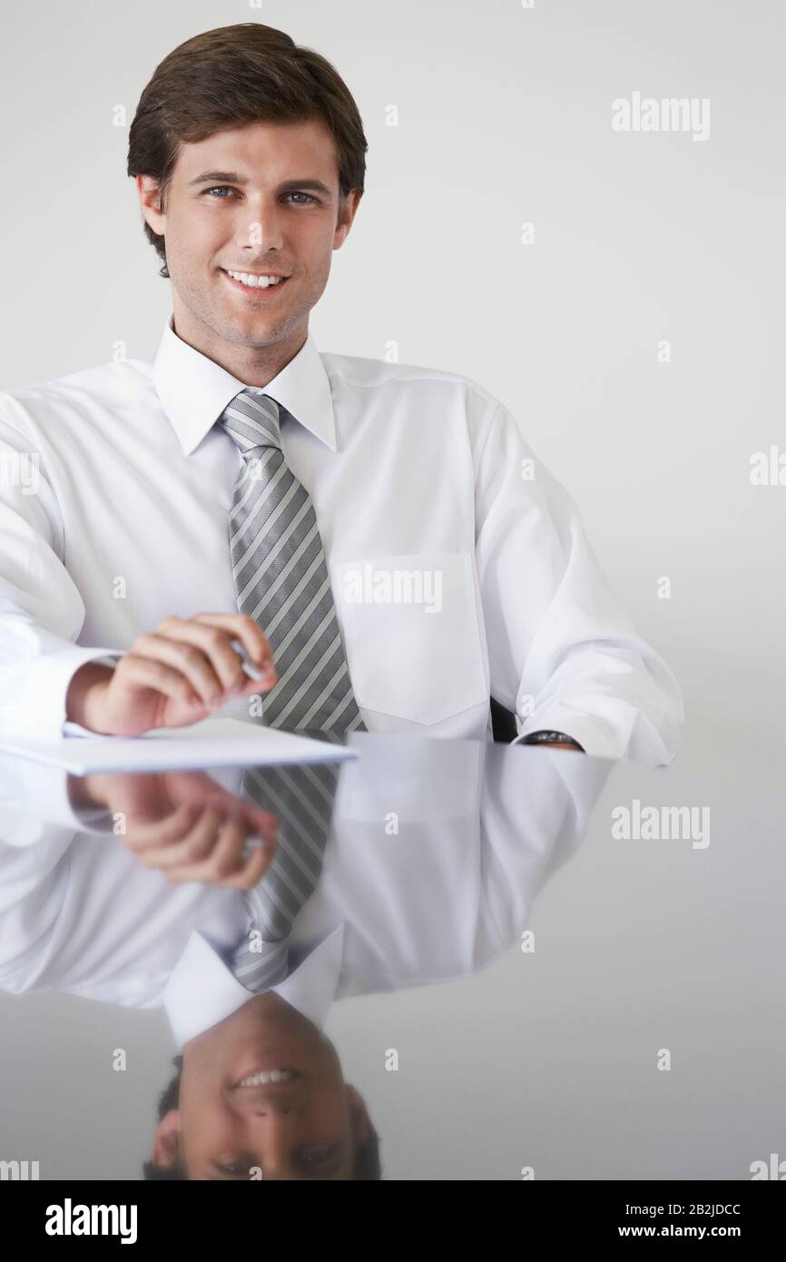 Business man sitting at conference table portrait Stock Photo - Alamy