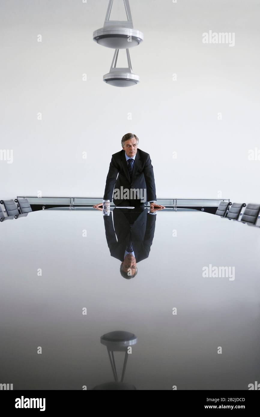 Business man standing at conference table Stock Photo - Alamy