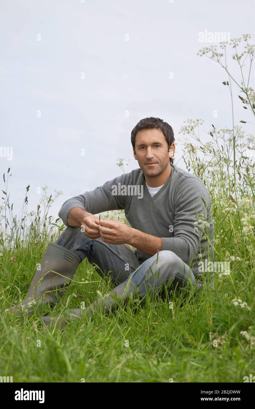 Man sitting in field portrait Stock Photo - Alamy