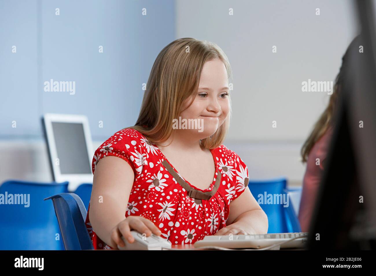 Girl (10-12) with Down syndrome using computer in computer lab Stock ...