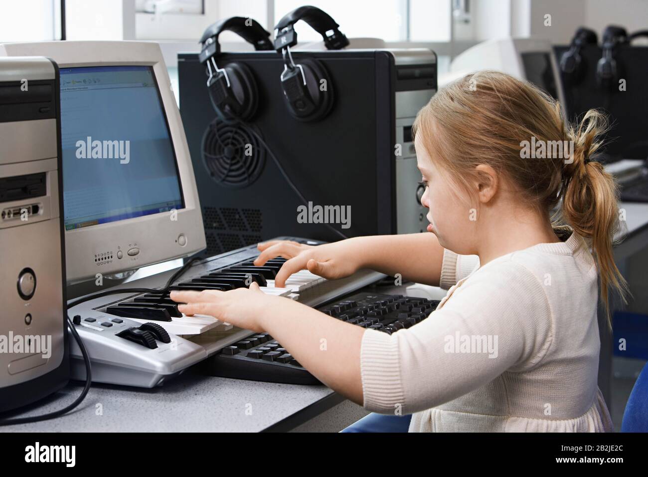 Girl (10-12) with Down syndrome playing keyboard Stock Photo - Alamy