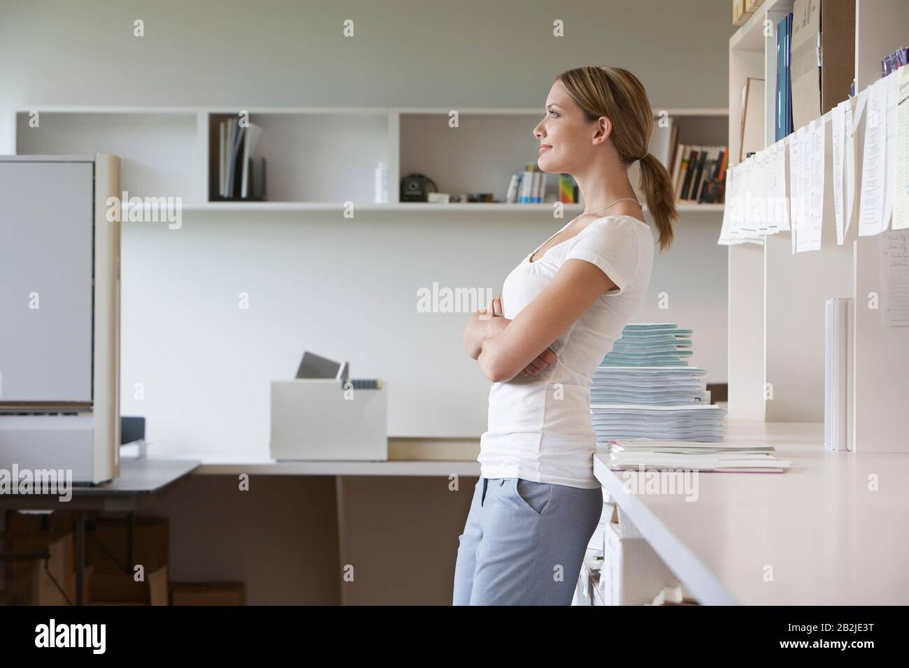 Office worker leaning on bench in office side view Stock Photo - Alamy