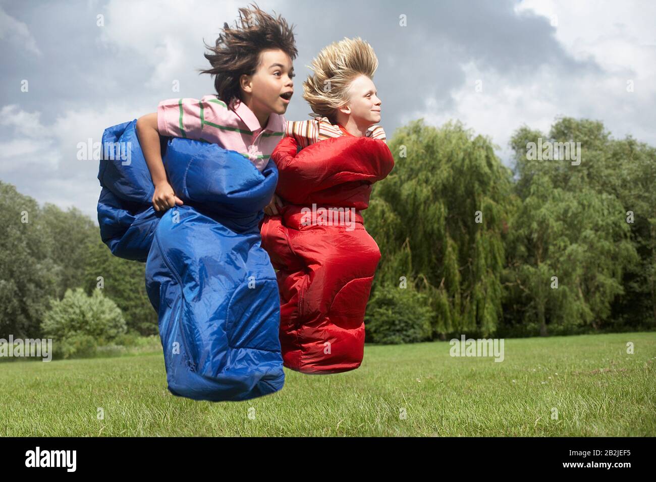 Two boys (7-9) racing in sleeping bags Stock Photo - Alamy