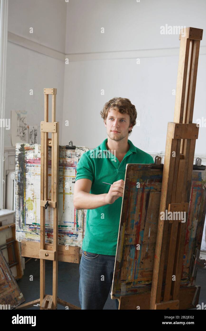 Artist painting at easel in studio Stock Photo - Alamy