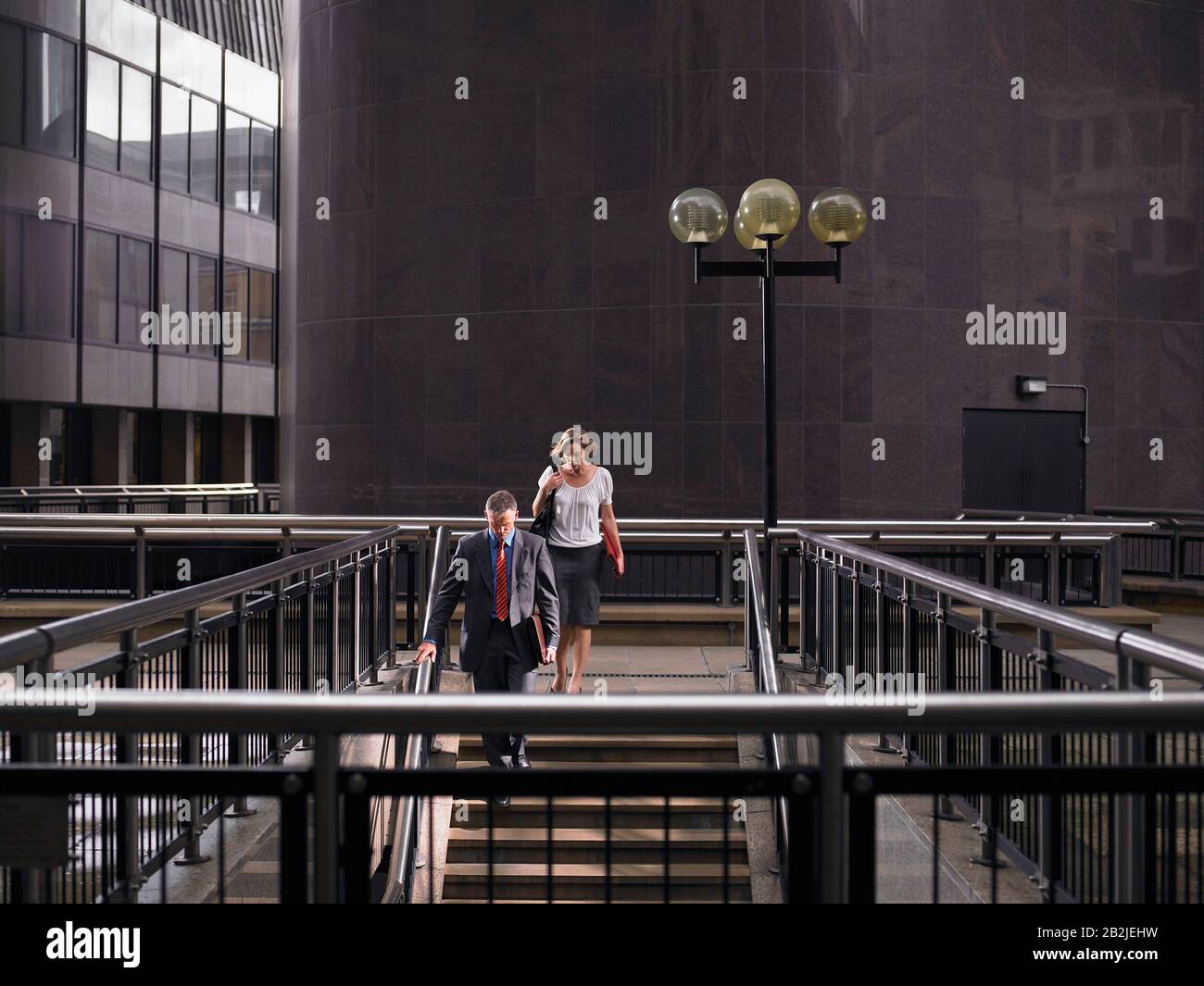 Two people descending steps Stock Photo - Alamy