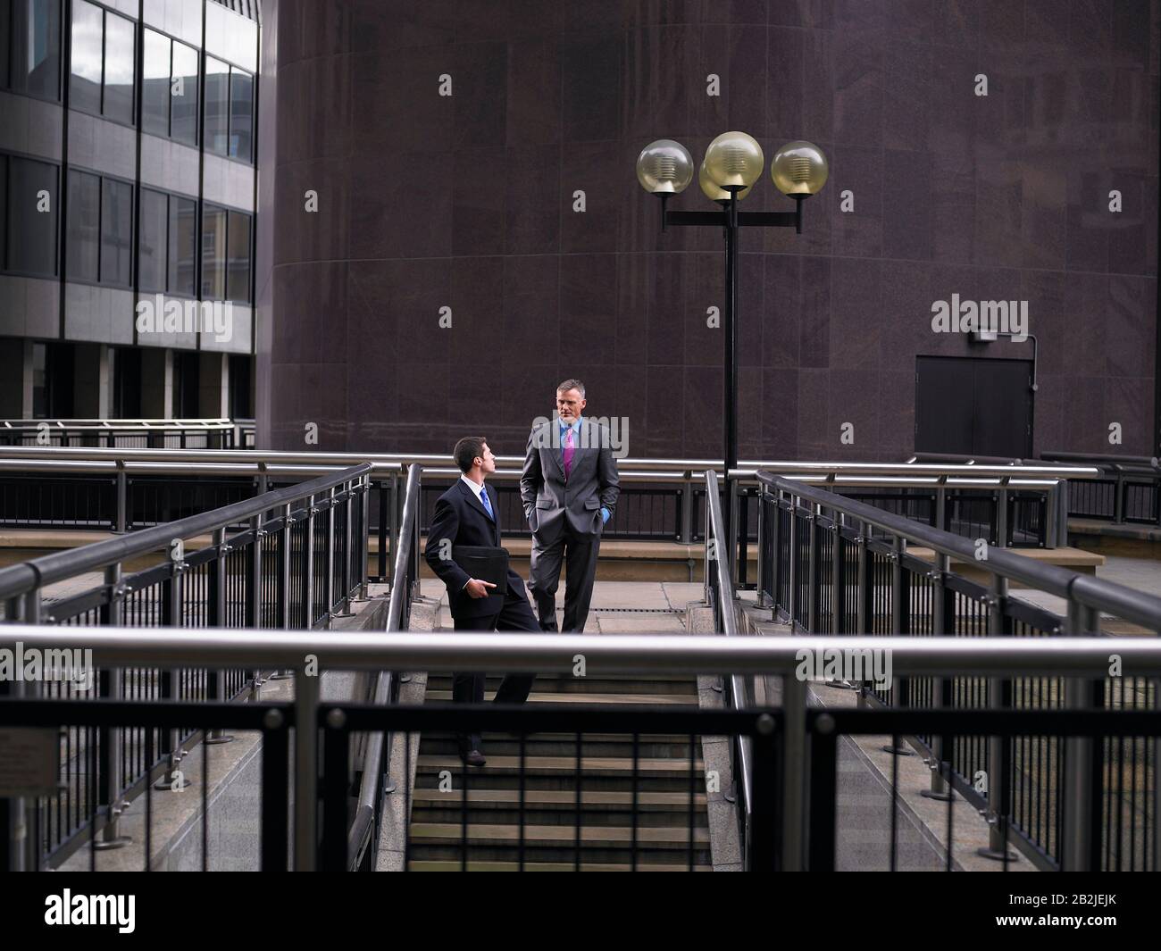 Two business men descending steps Stock Photo - Alamy