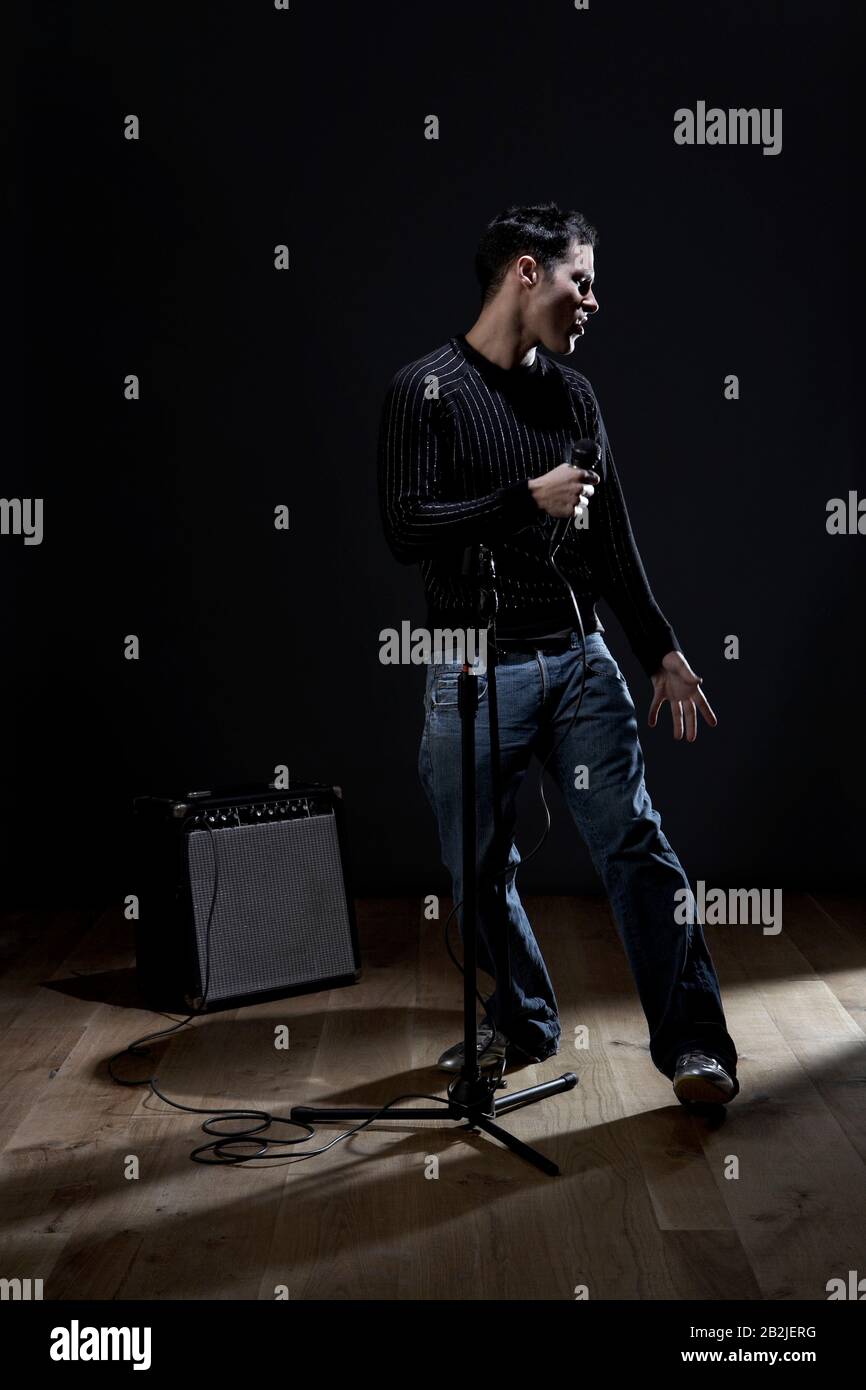 Young man singing on stage Stock Photo - Alamy