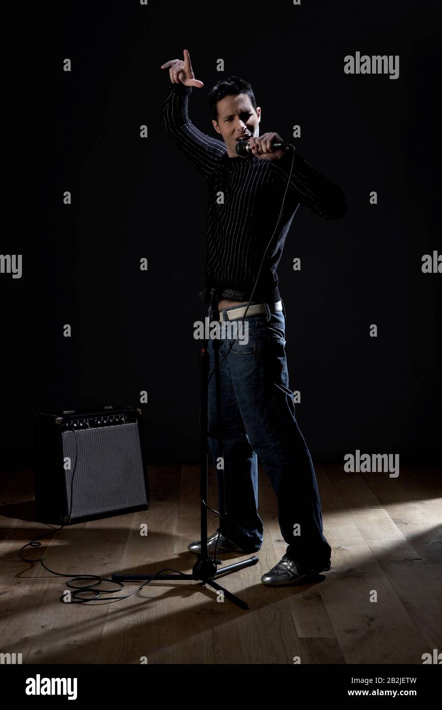 Young man singing on stage Stock Photo - Alamy