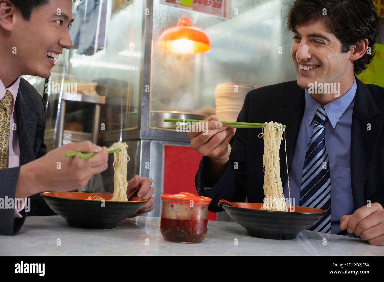 Two business men having lunch in Chinese bar Stock Photo - Alamy