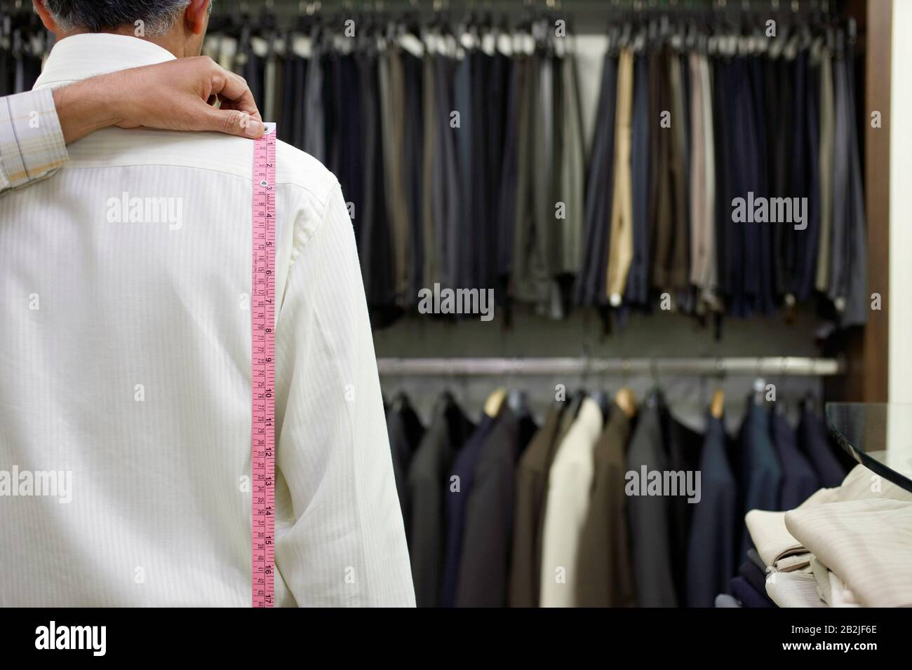 Tailor measuring business man with tape measure mid section back view ...