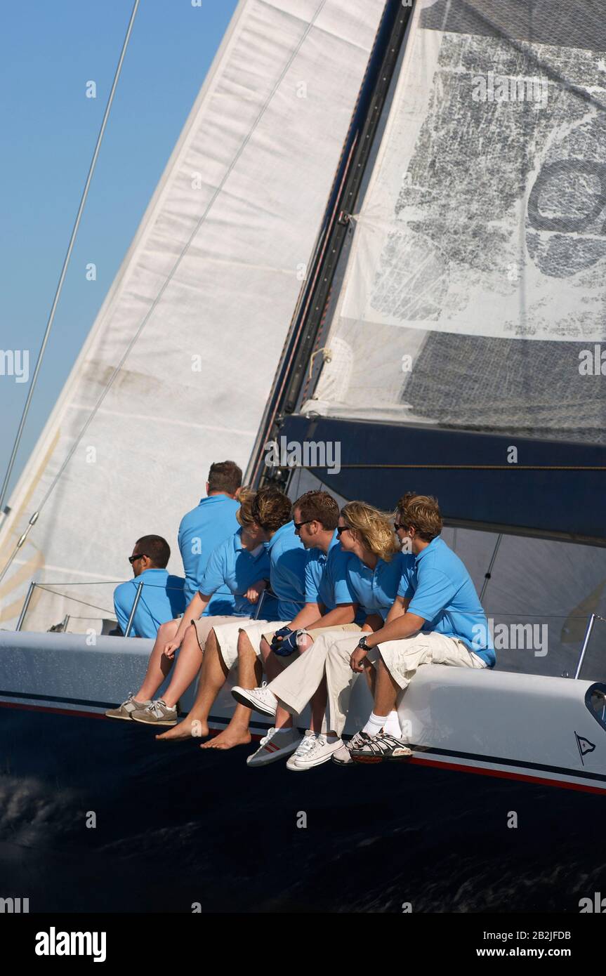 Sailing team sitting on sailboat Stock Photo - Alamy