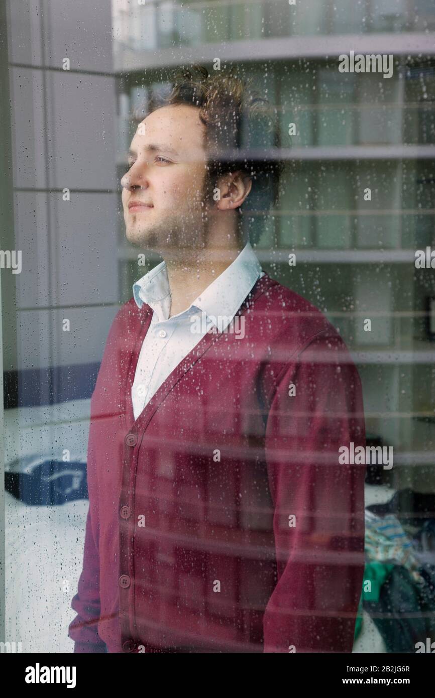 Man looking through window Stock Photo - Alamy