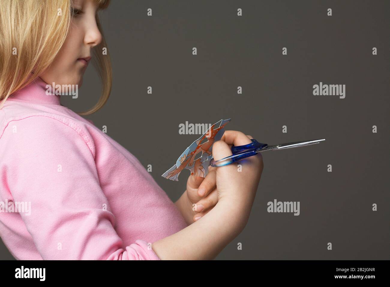 Girl (3-4) with scissors and cut-out Stock Photo - Alamy