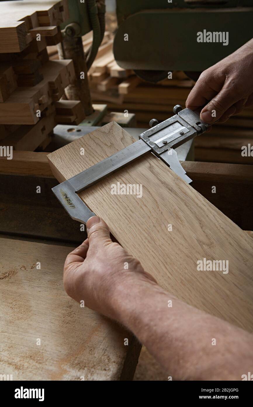 Carpenter Measuring Thickness of Wood Piece Stock Photo - Alamy