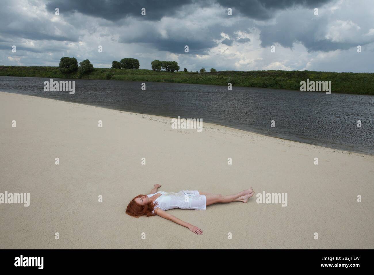 Woman Lying on Beach Along River Stock Photo - Alamy