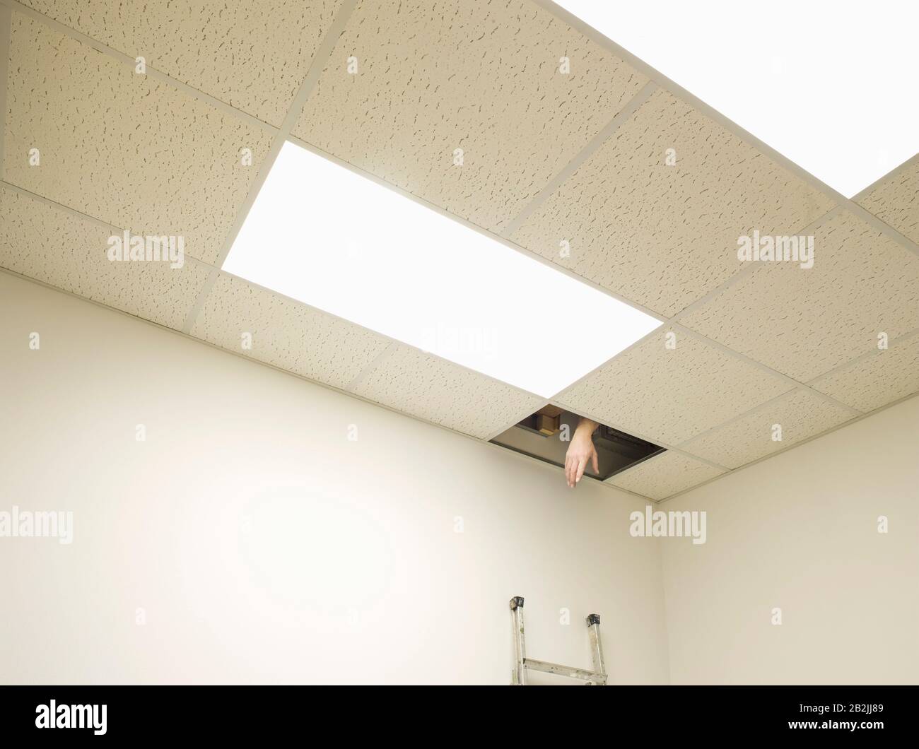 Hand reaching from hole in ceiling Stock Photo - Alamy