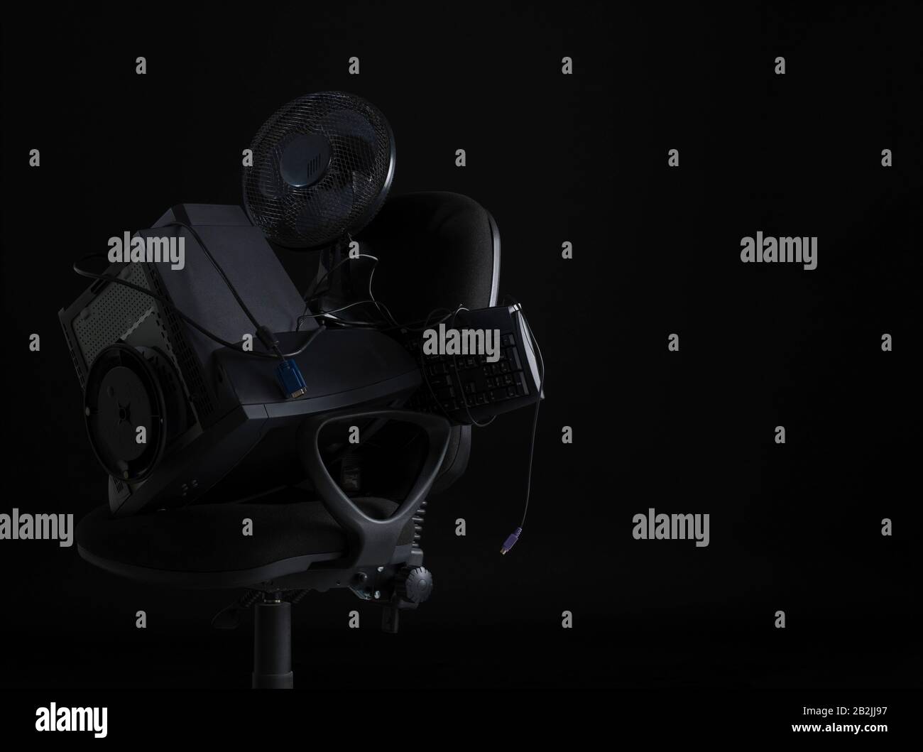 Computer equipment and fan on office chair Stock Photo - Alamy