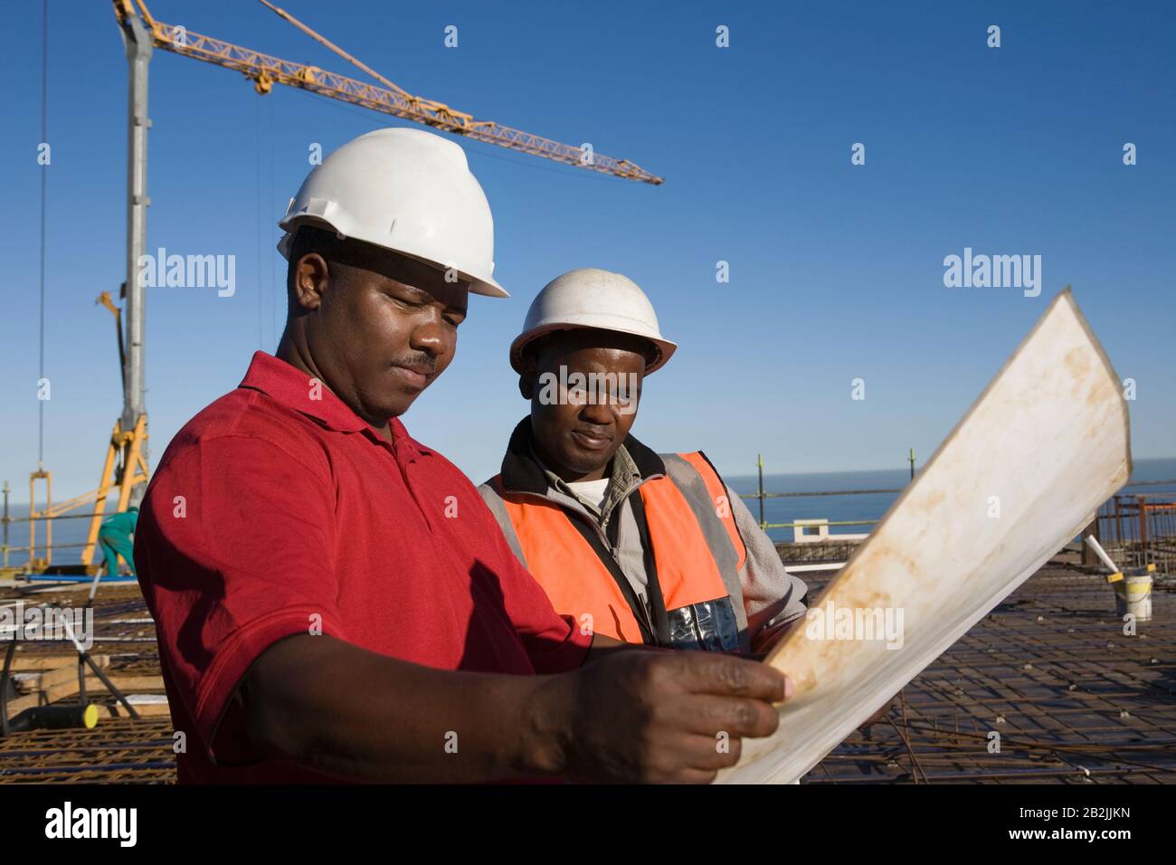 Workmen survey building plans Stock Photo - Alamy