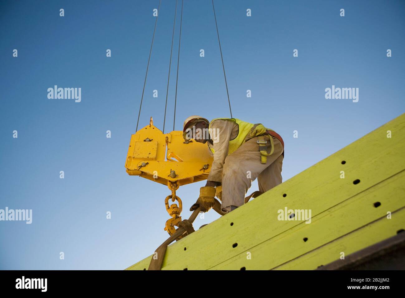 Workman fixes harness of hook block to building material Stock Photo ...