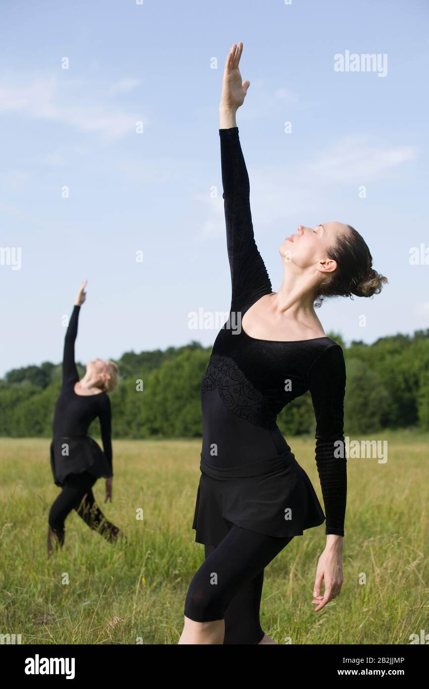 Young women stretch in a field Stock Photo - Alamy