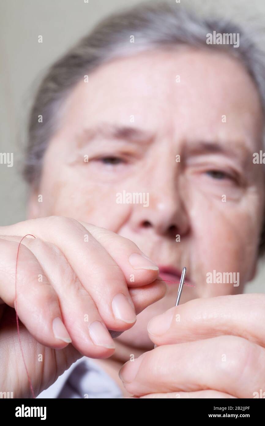 Old woman threading a needle hi-res stock photography and images - Alamy