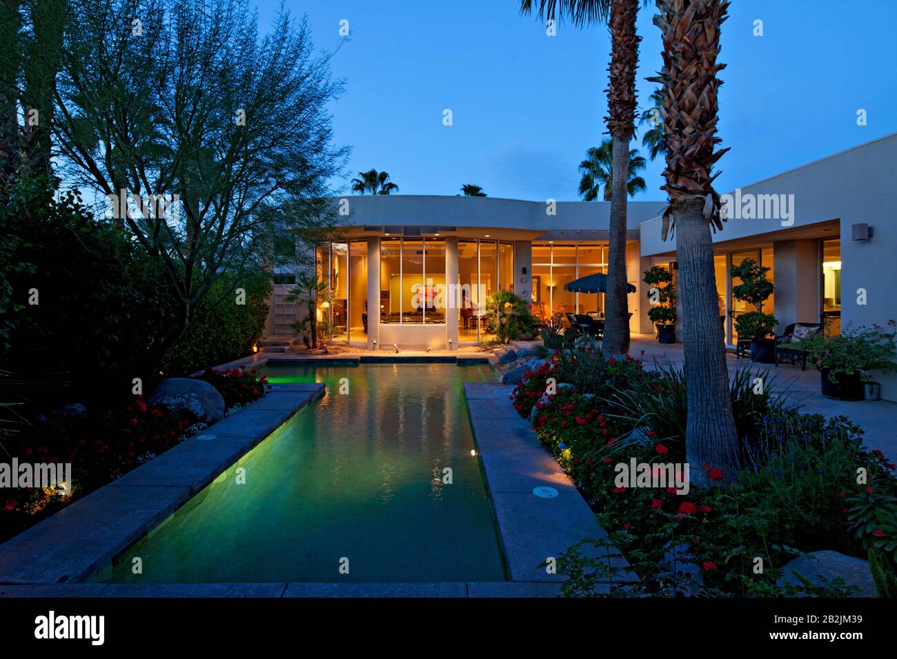 Swimming pool outside mansion at dusk Stock Photo - Alamy